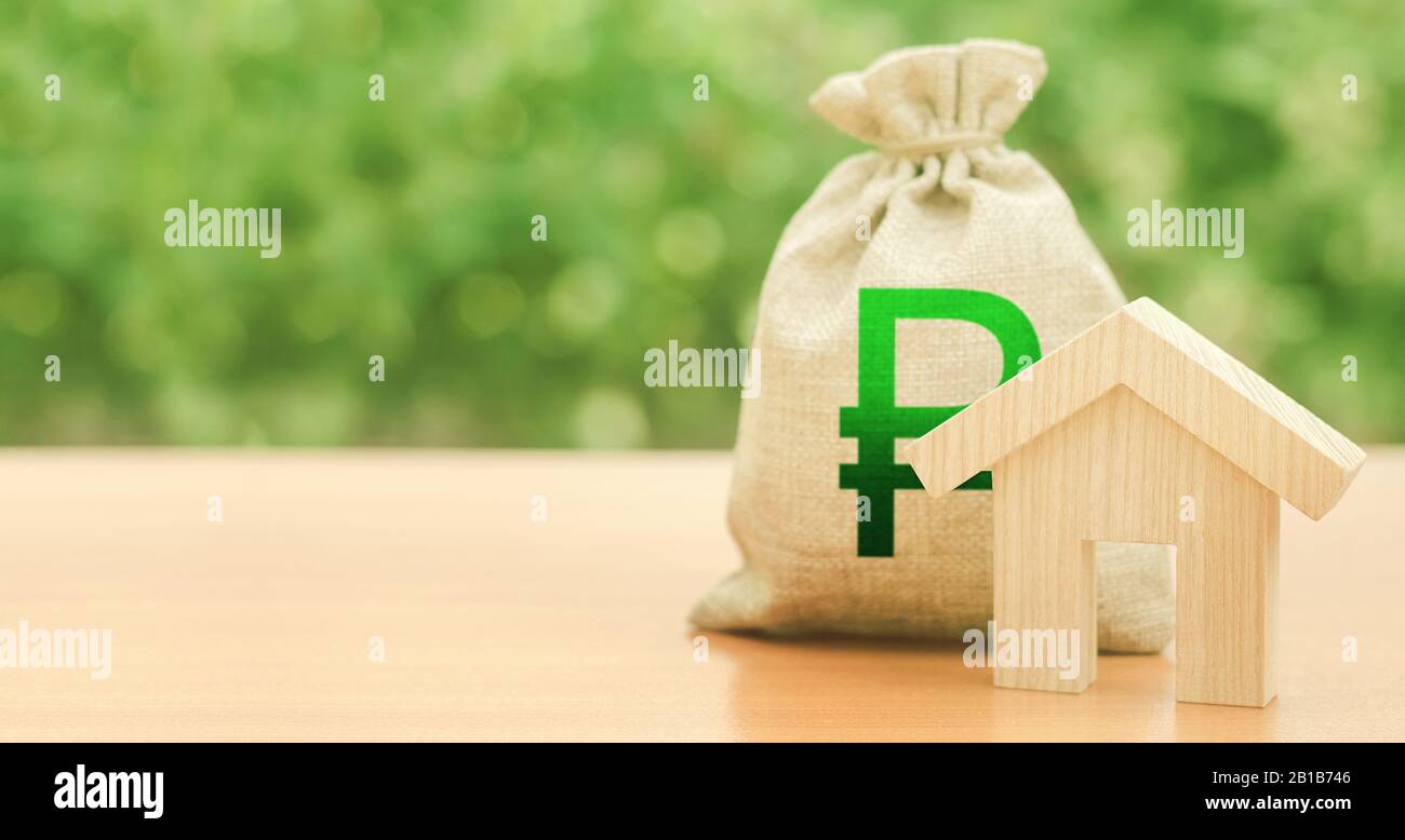 Wooden house figurine and russian ruble money bag. Family home budget ...