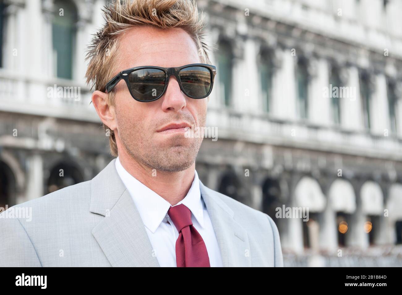 European businessman with disheveled hair standing in front of classic ...
