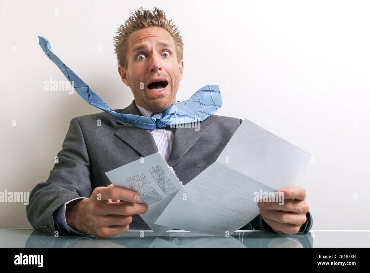 Shocked businessman opening a letter with a wide-eyed gasp of surprise ...