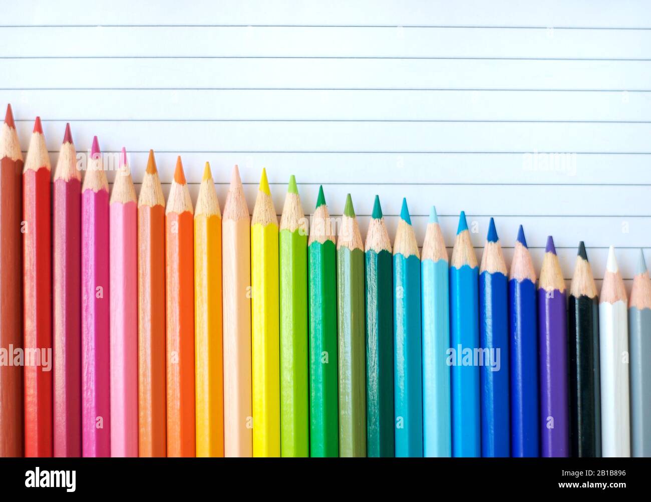 Colored pencils act as a bar graph marking a downward trend along a ...