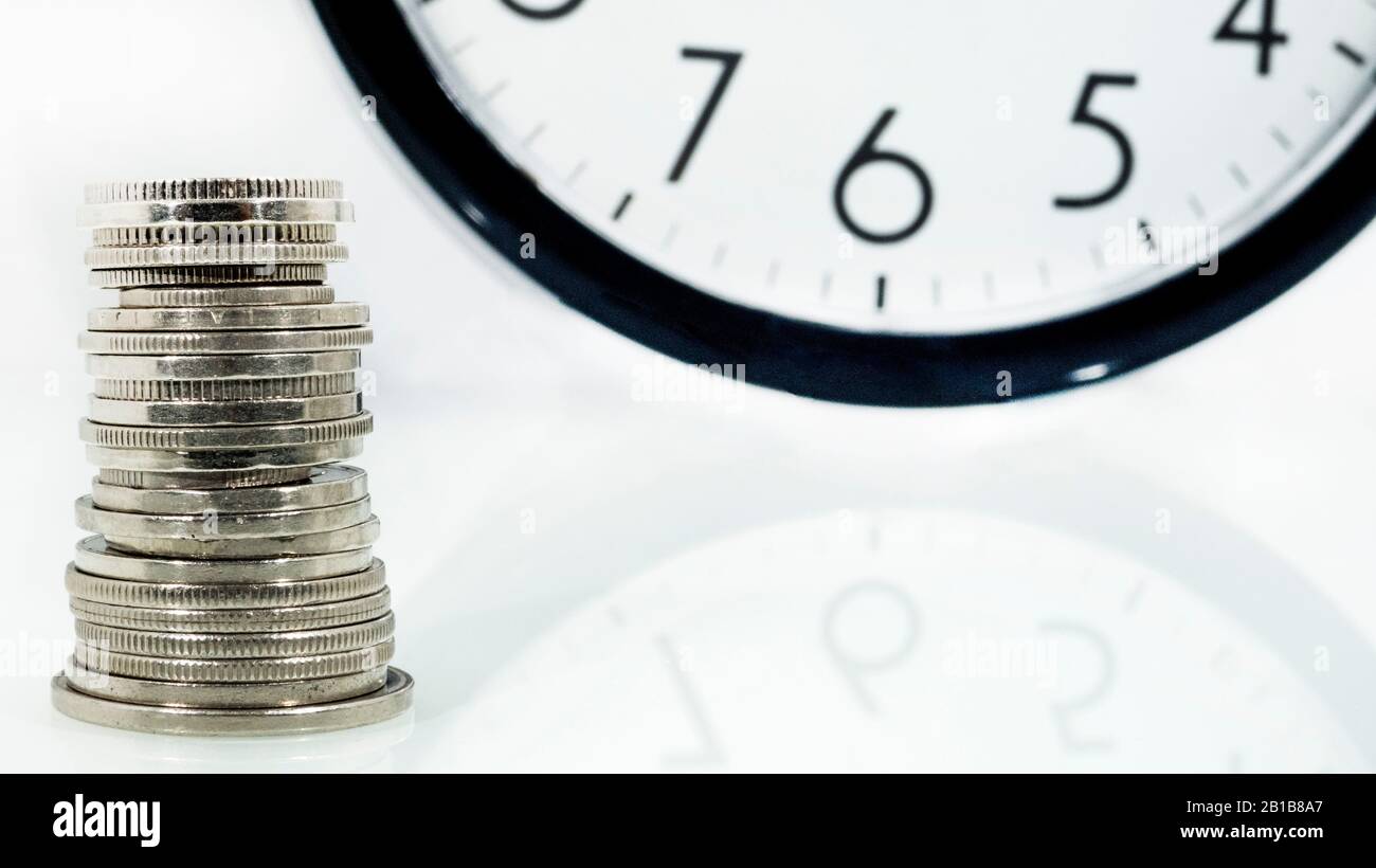 TIME IS MONEY concept: Alarm clock and with coins Stock Photo - Alamy