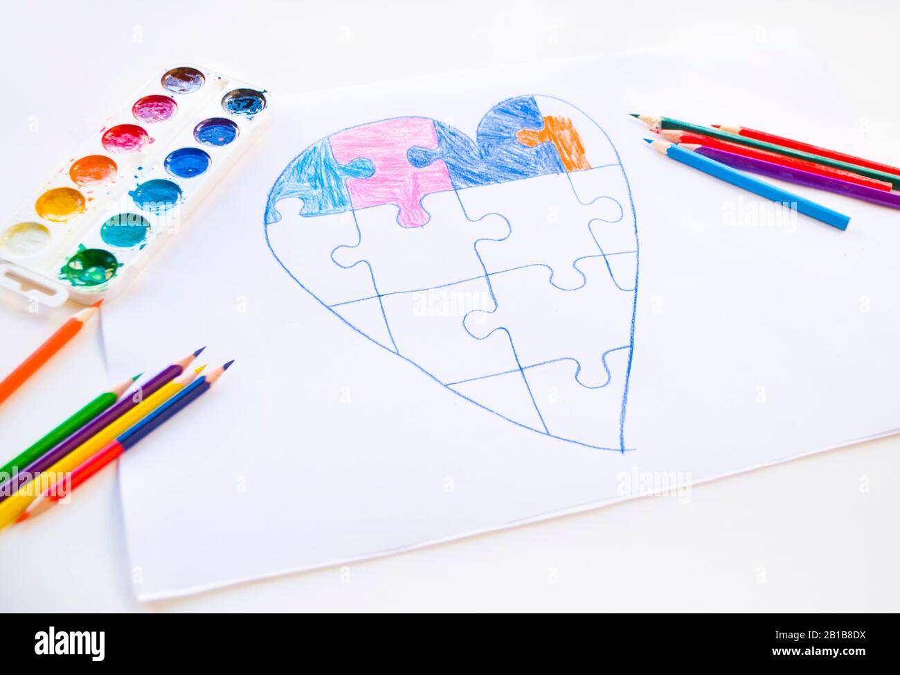 Colorful child drawn heart with jigsaw puzzle on white background as a ...