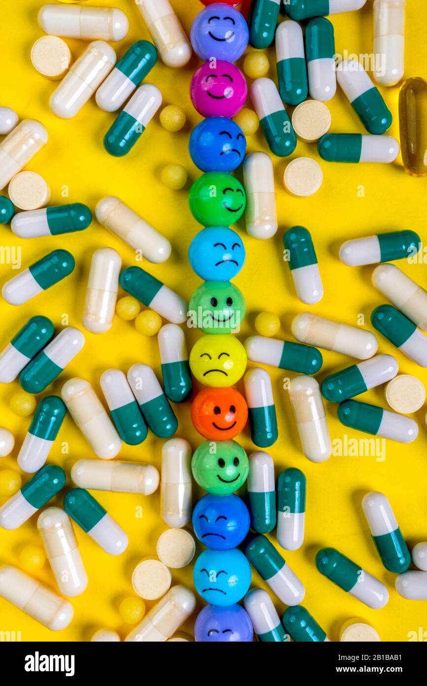 Multi color pills, tablets and capsules with colorful funny faces with ...