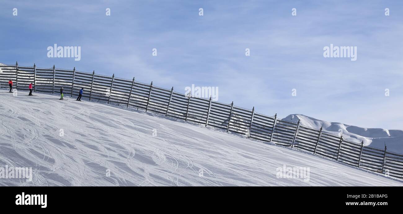 Snowy ski track prepared by snowcat with trace from skis and snowboards ...
