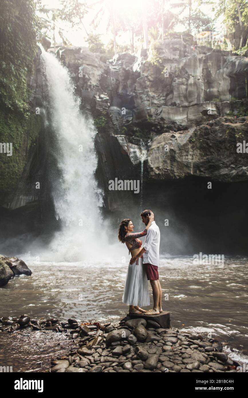 Spanish couple in love kissing with amazing view of waterfall. Happy ...