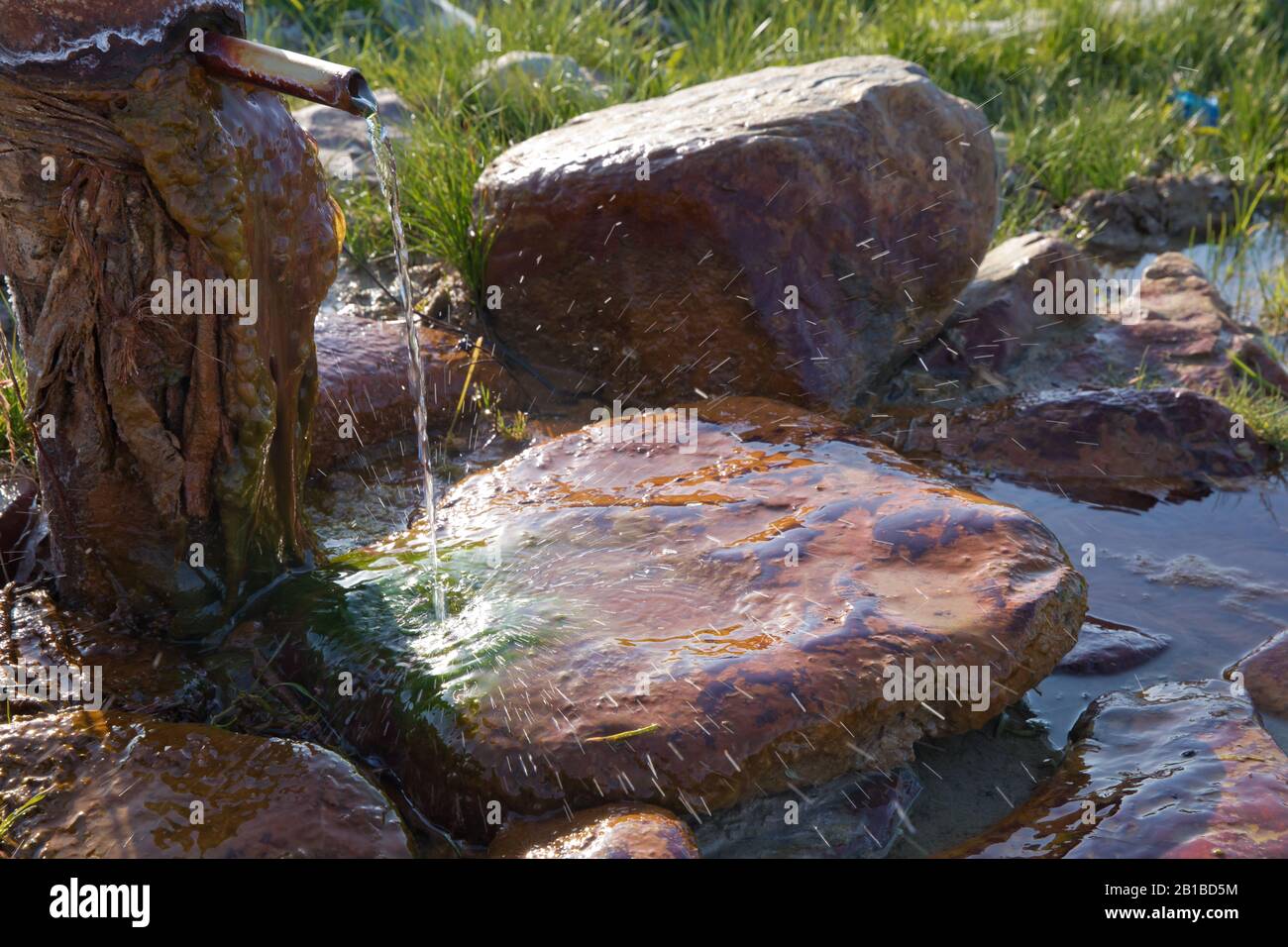 iron pipe flowing clean drinking water . spring water from the ground ...