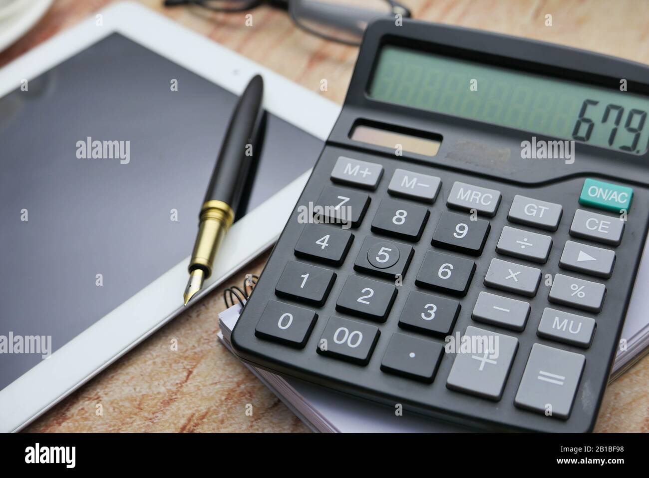 top view of calculator and pen on color background Stock Photo - Alamy