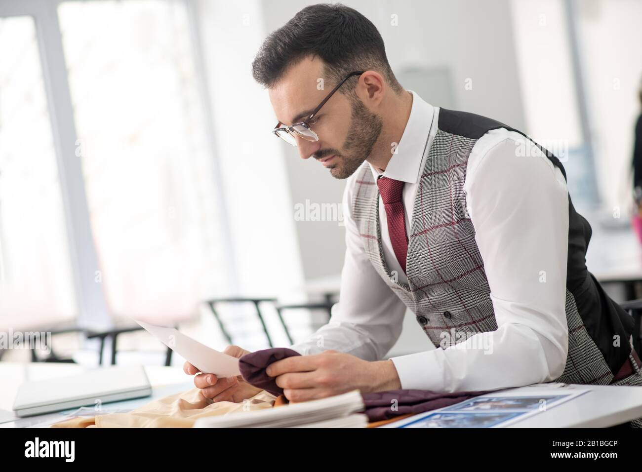 Male tailor sitting, holding pattern and cloth Stock Photo - Alamy