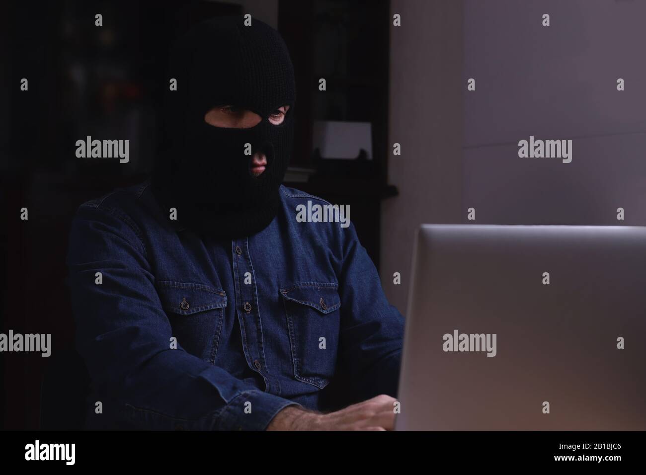 Thief stealing data from laptop Stock Photo - Alamy