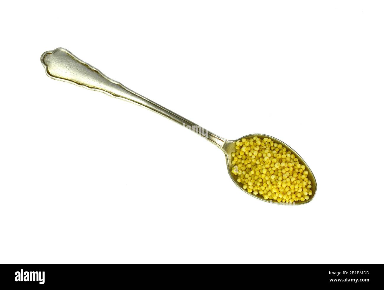 Millet grains in a silver spoon isolated on white background Stock ...