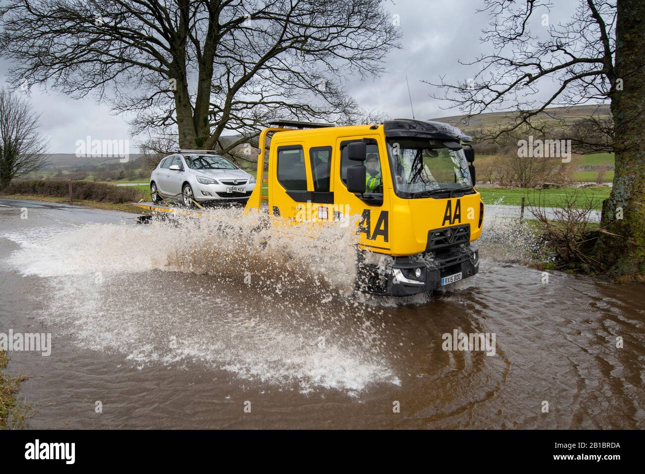 AA recovery van with a car on going through flooding on the A684 ...