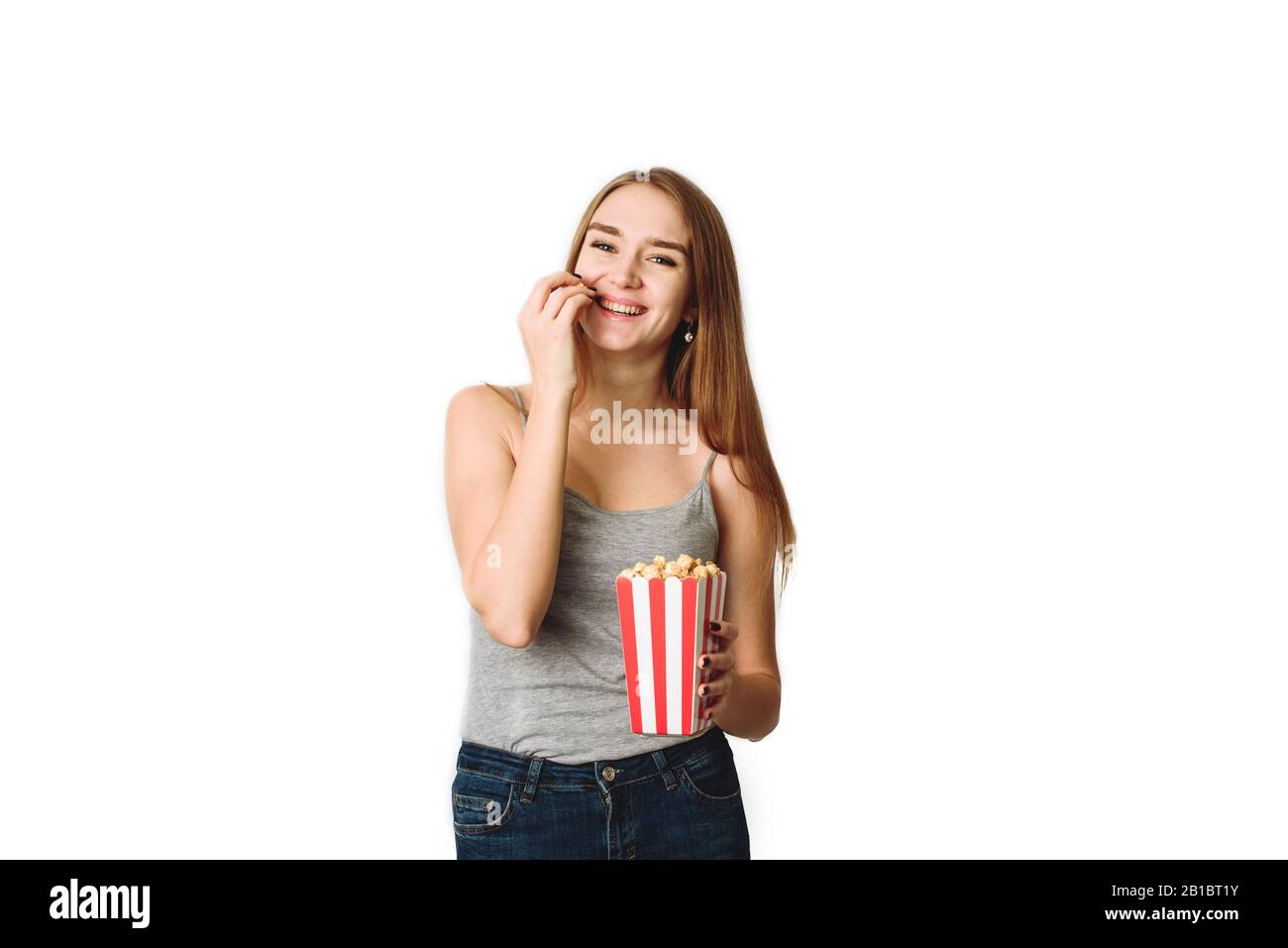 girl fooling around with popcorn in the studio. Portrait of a laughing ...