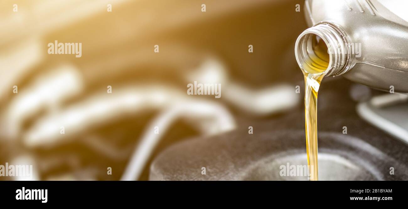 Pouring oil to car engine. Fresh oil poured during an oil change to a ...