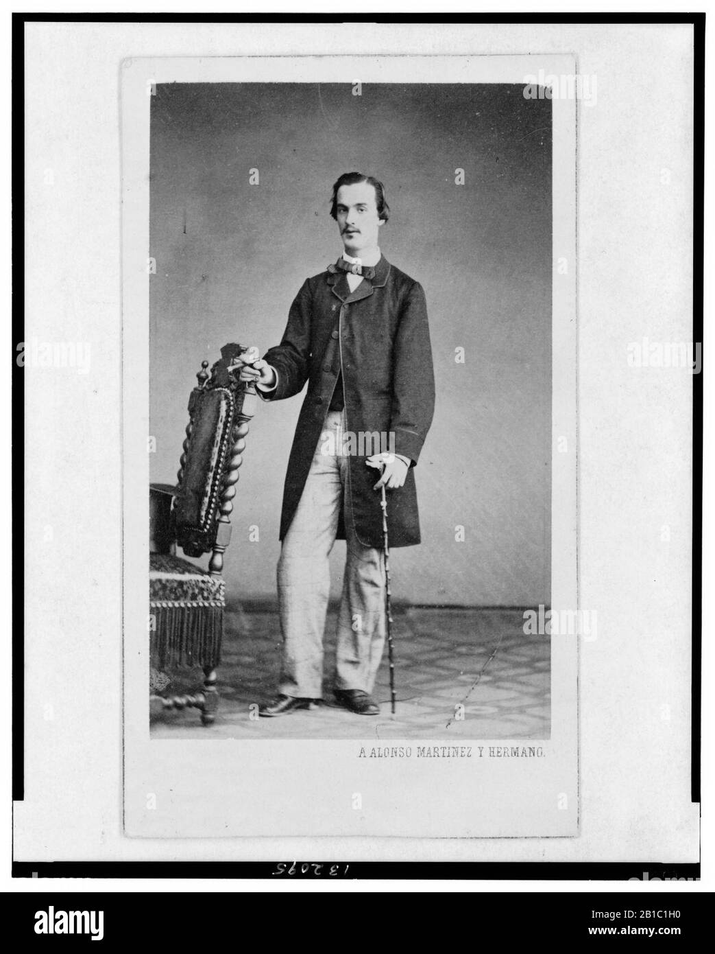 Full-length portrait of a man, standing, facing front, holding a cane ...