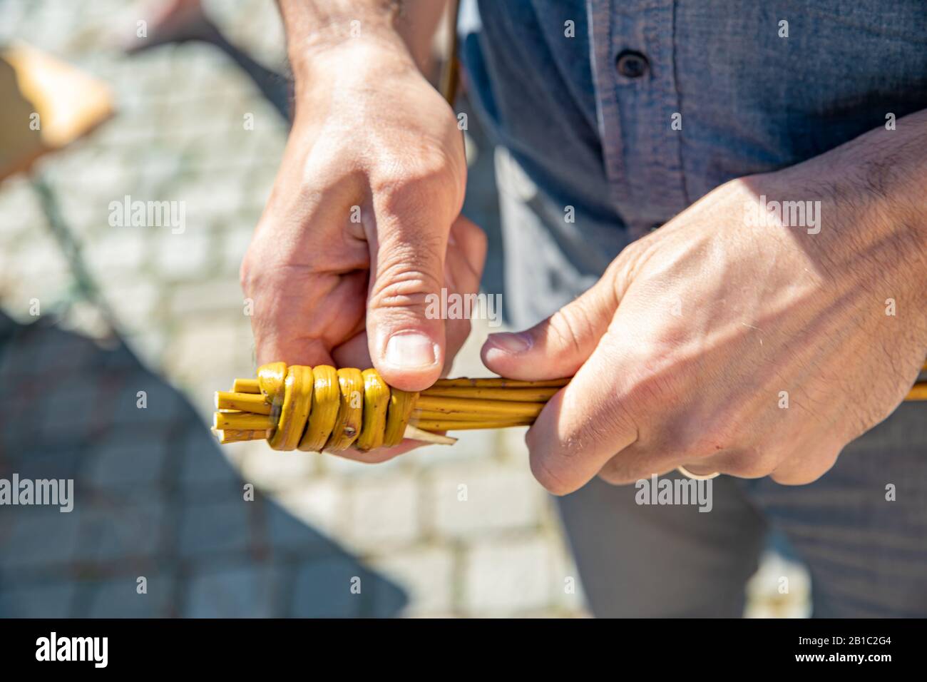 a man weaves his Easter whip from a rod Stock Photo - Alamy