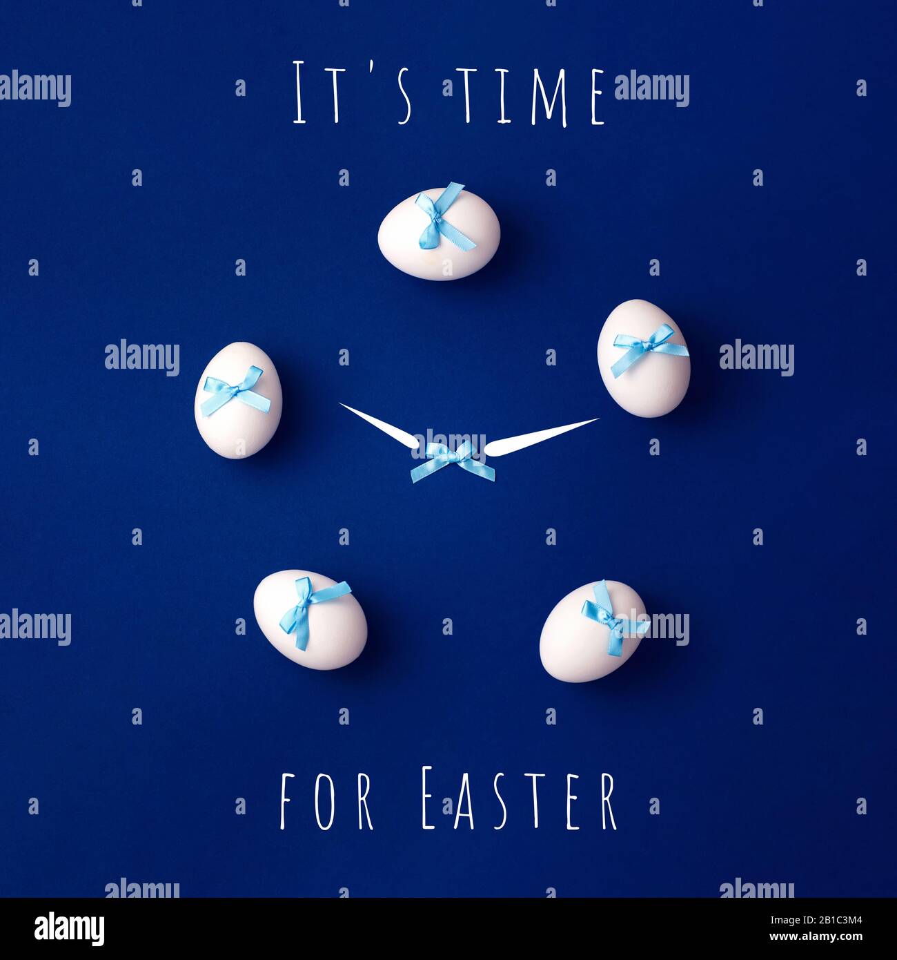 Watch with arrows of white eggs with blue bows. Concept on the theme of ...