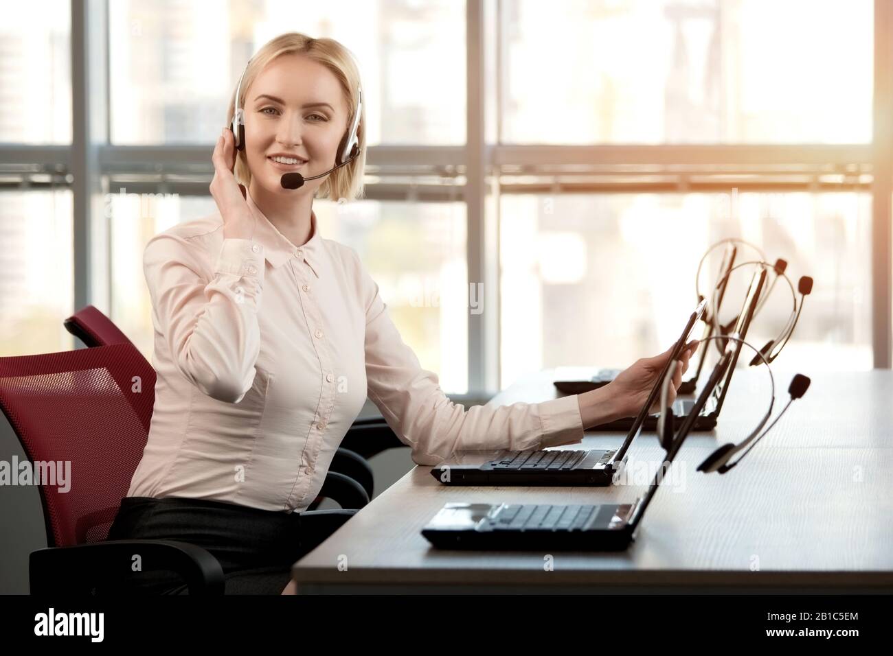 Pretty female support center operator with headset Stock Photo - Alamy