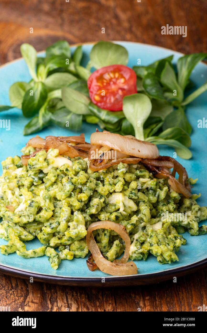 bavarian spinach spaetzle on a blue plate Stock Photo - Alamy