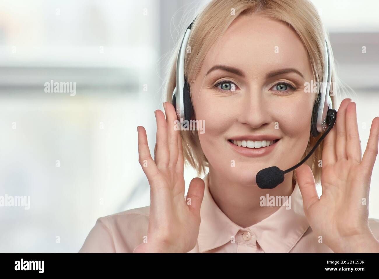 Happy cheerful blond lady with headset portrait Stock Photo - Alamy