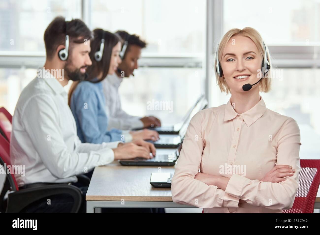 Female operator in headset with folded hands Stock Photo - Alamy