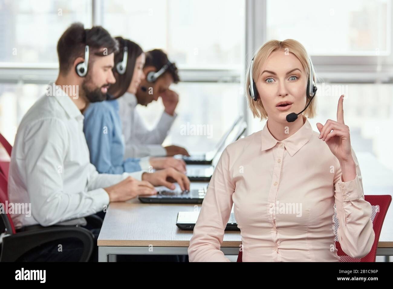 Female operator holding finger up having idea Stock Photo - Alamy