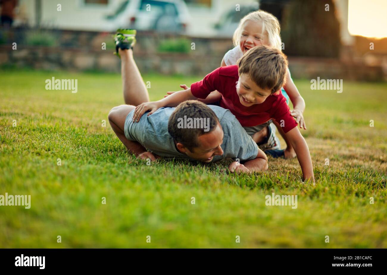 Father playing with his children in their back yard Stock Photo - Alamy