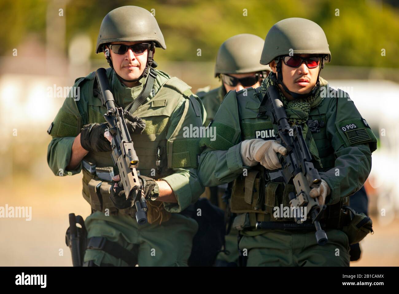Three police officers holding a gun during an exercise at a training ...