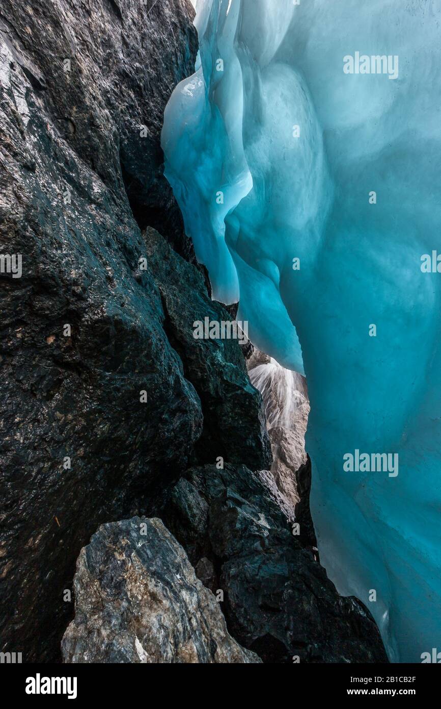 Beautiful blue ice next to water flowing over large stones. A small ...