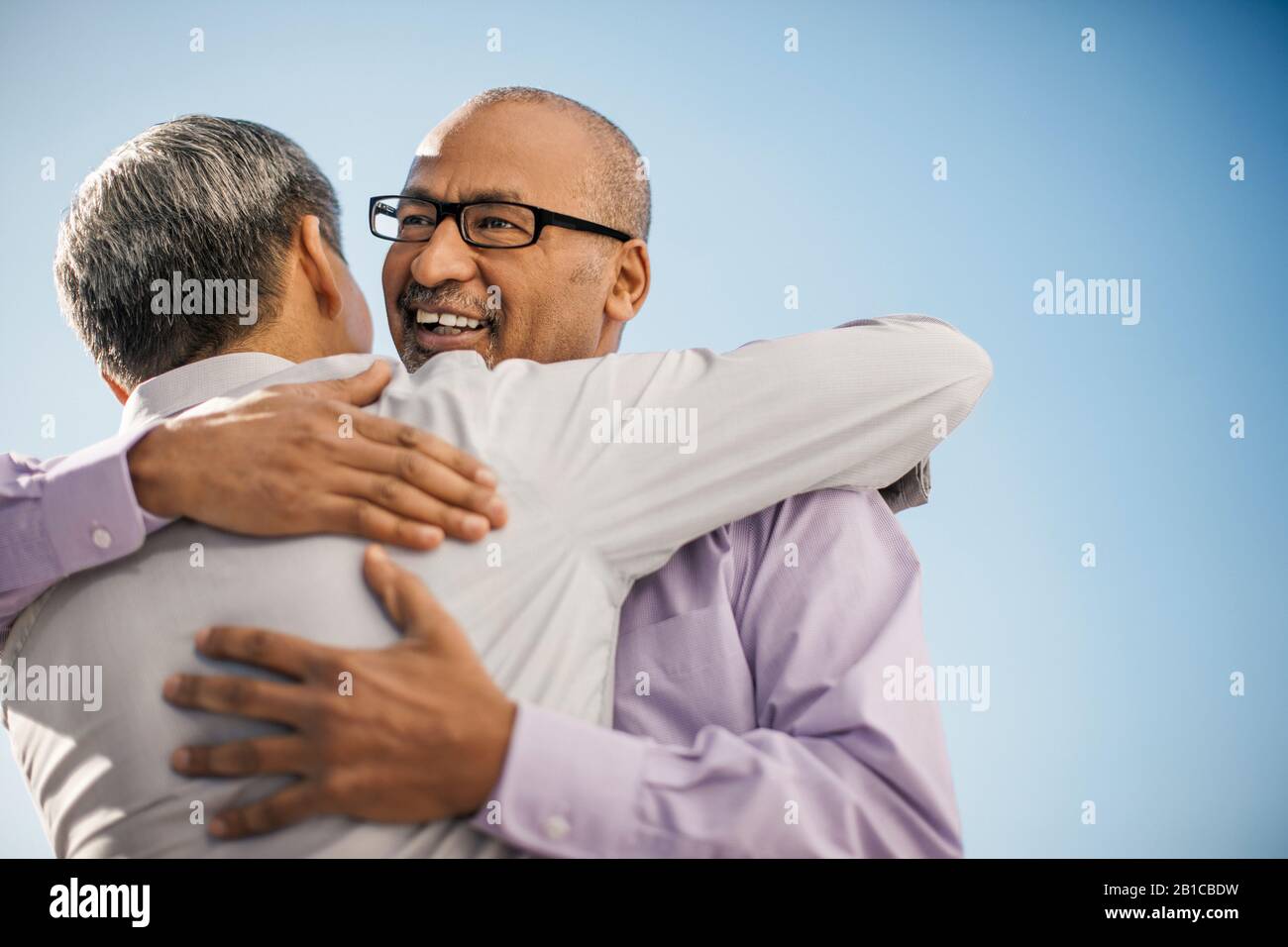 Businessmen greeting each other with a hug Stock Photo - Alamy