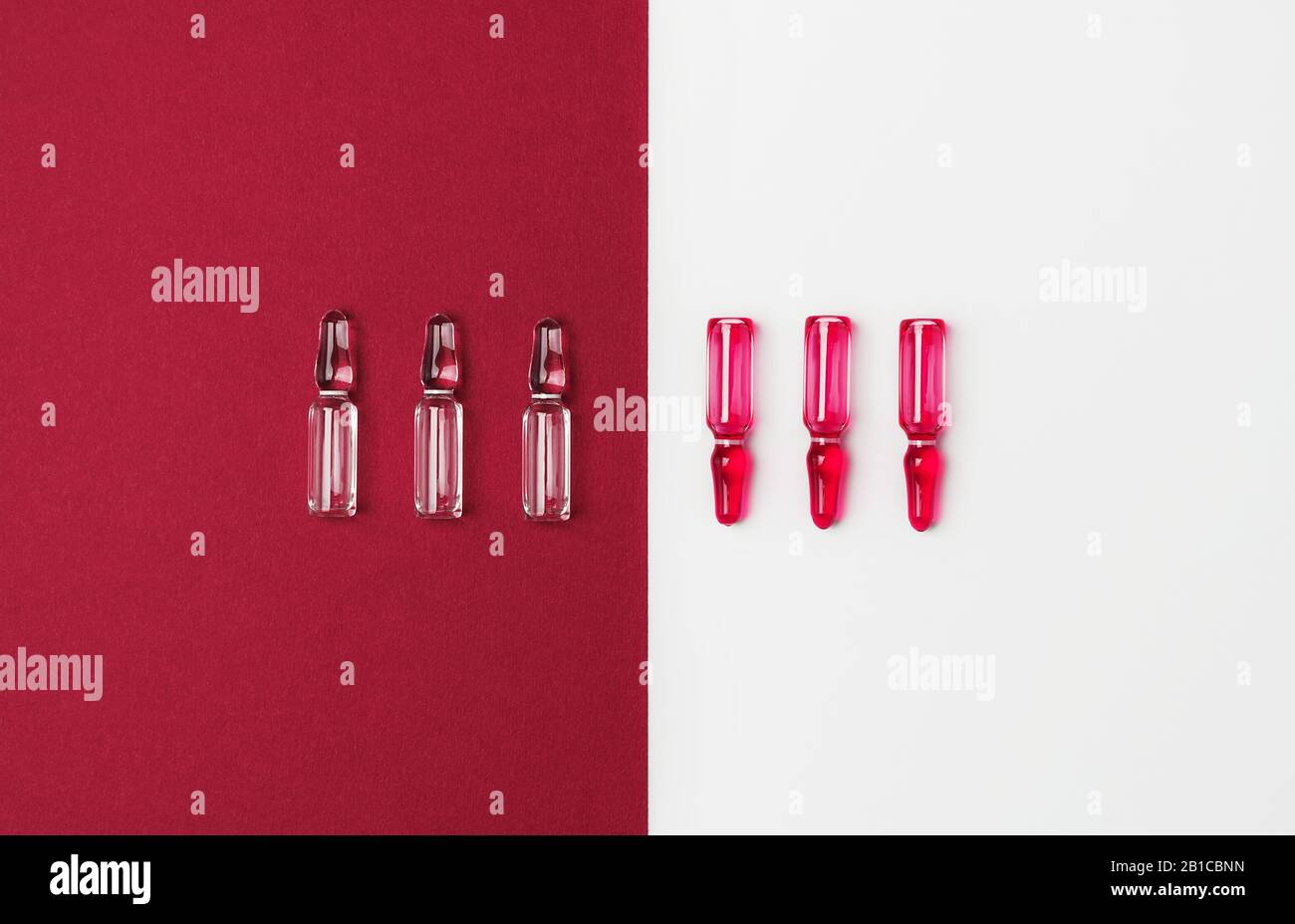 Line of ampules for injections with red and transparent liquid on ...