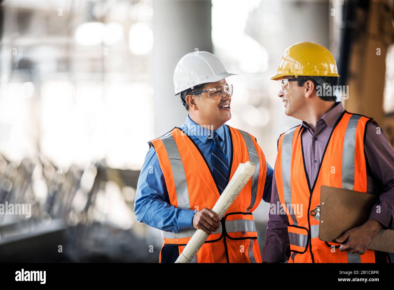 Workers at construction site discuss progress Stock Photo - Alamy