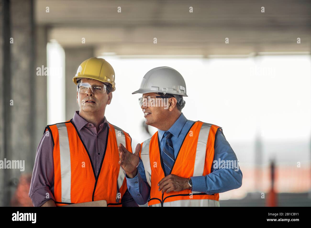 Two construction managers talking on building site Stock Photo - Alamy