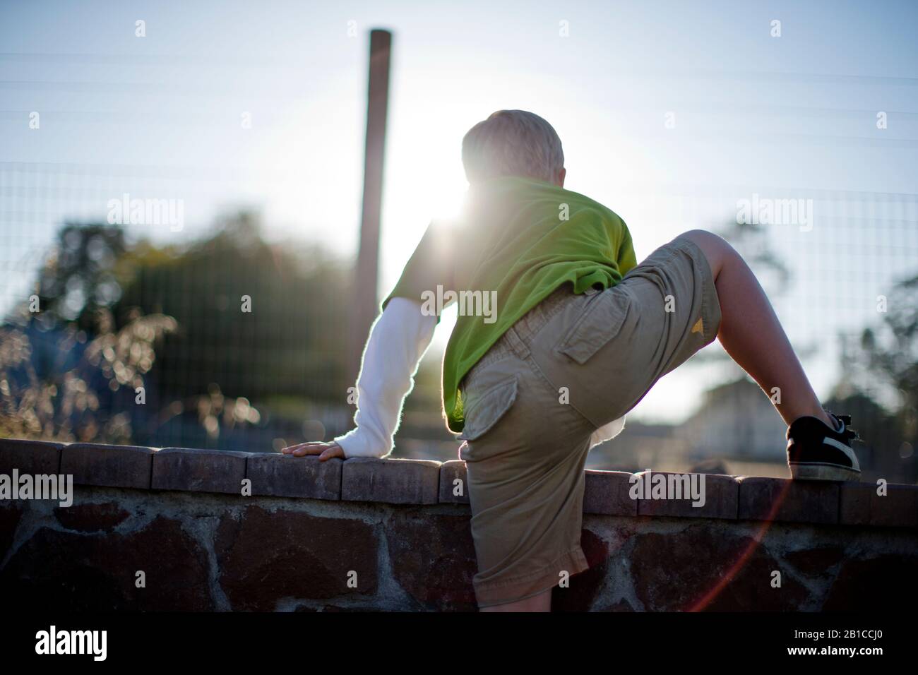 Boy climbing over wall hi-res stock photography and images - Alamy