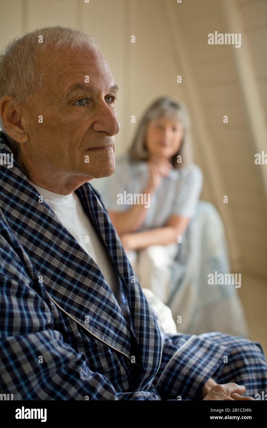 Concerned senior woman sitting with her husband Stock Photo - Alamy