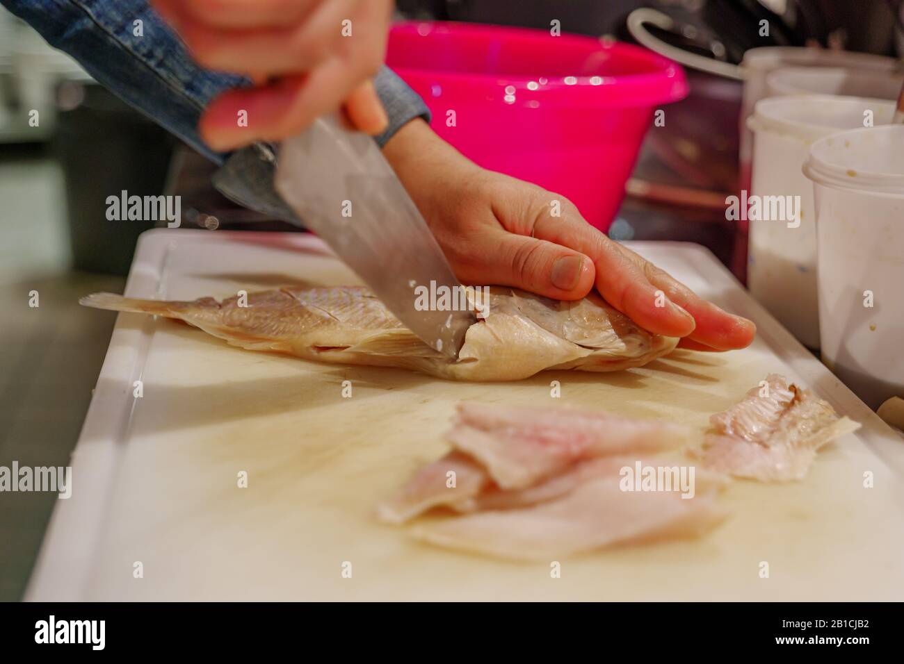 Chef'hand use knife for cut and slice red snapper fish on white ...