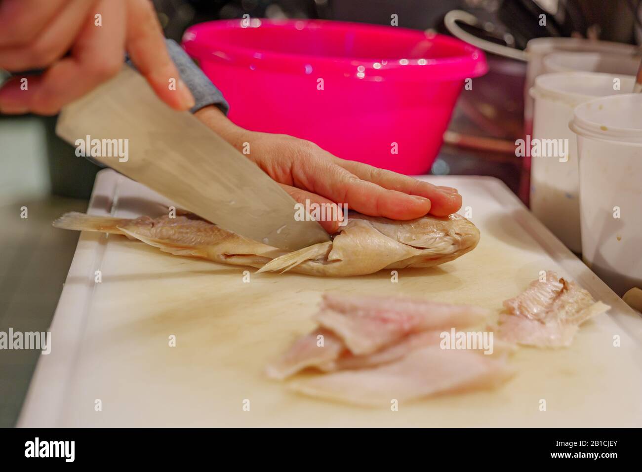 Chef'hand use knife for cut and slice red snapper fish on white ...
