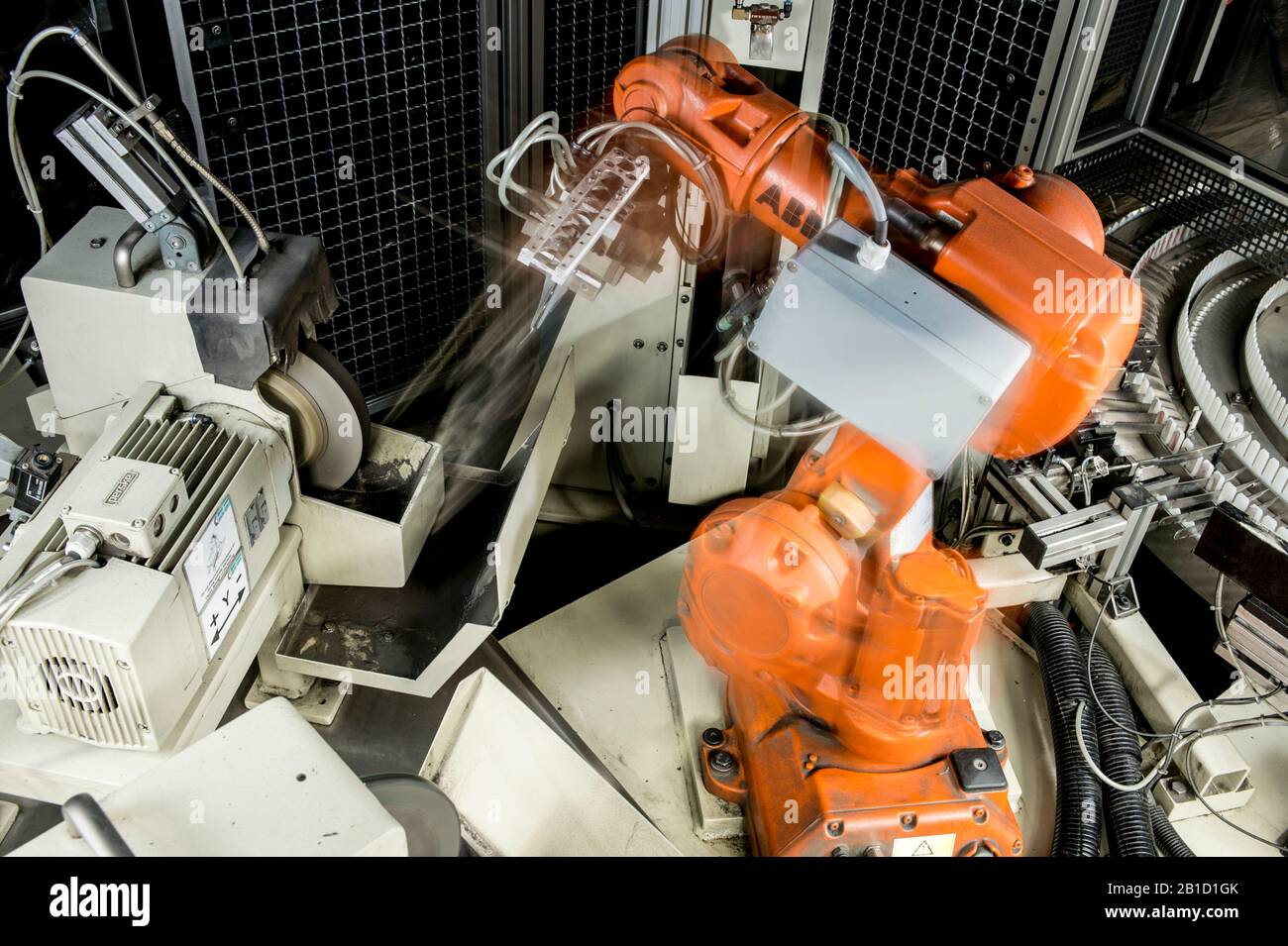 Knives being sharpened with a grinder by an Indusrtial Robot arm Stock ...