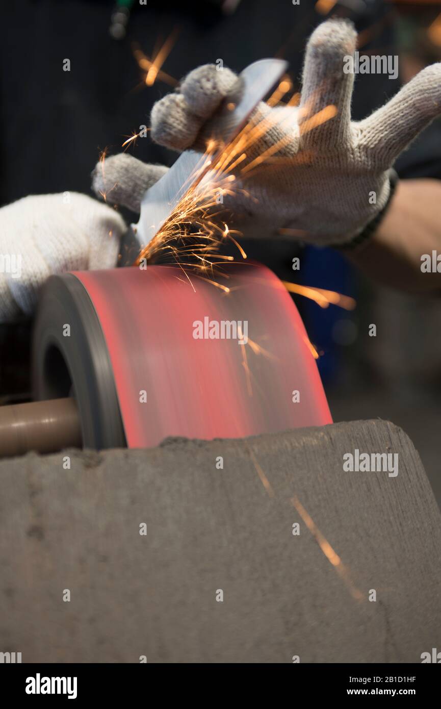 Polishing knife blade on sander Stock Photo - Alamy
