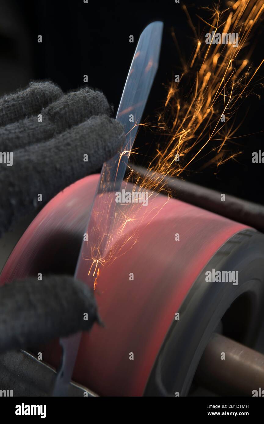 Polishing knife blade on sander Stock Photo - Alamy