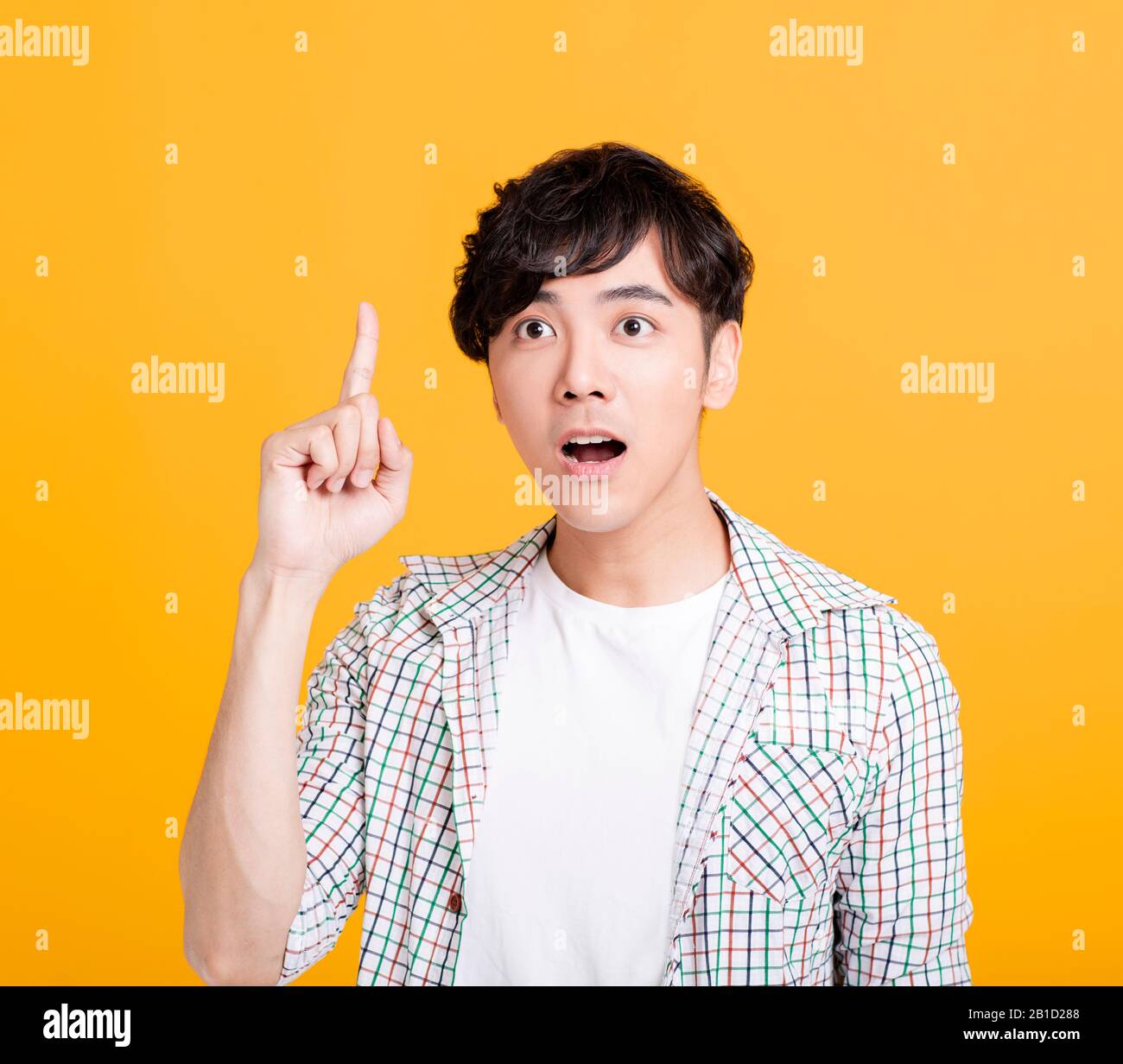 surprised young man hand pointing up Stock Photo - Alamy