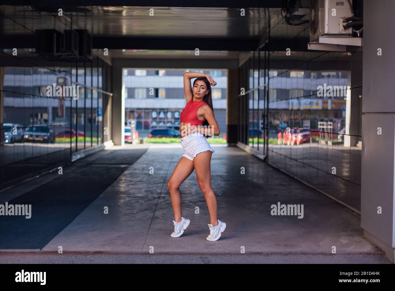 Young brunette woman dancing in arch of building Stock Photo - Alamy