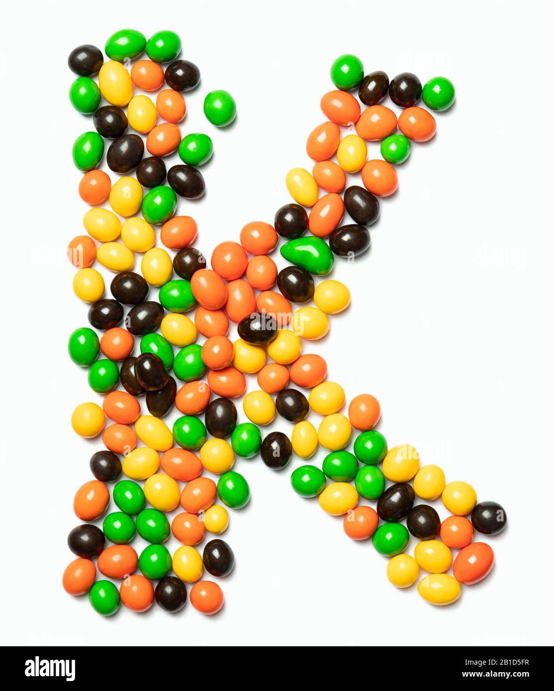 Letter K of the English alphabet from multicolored round chocolates on ...