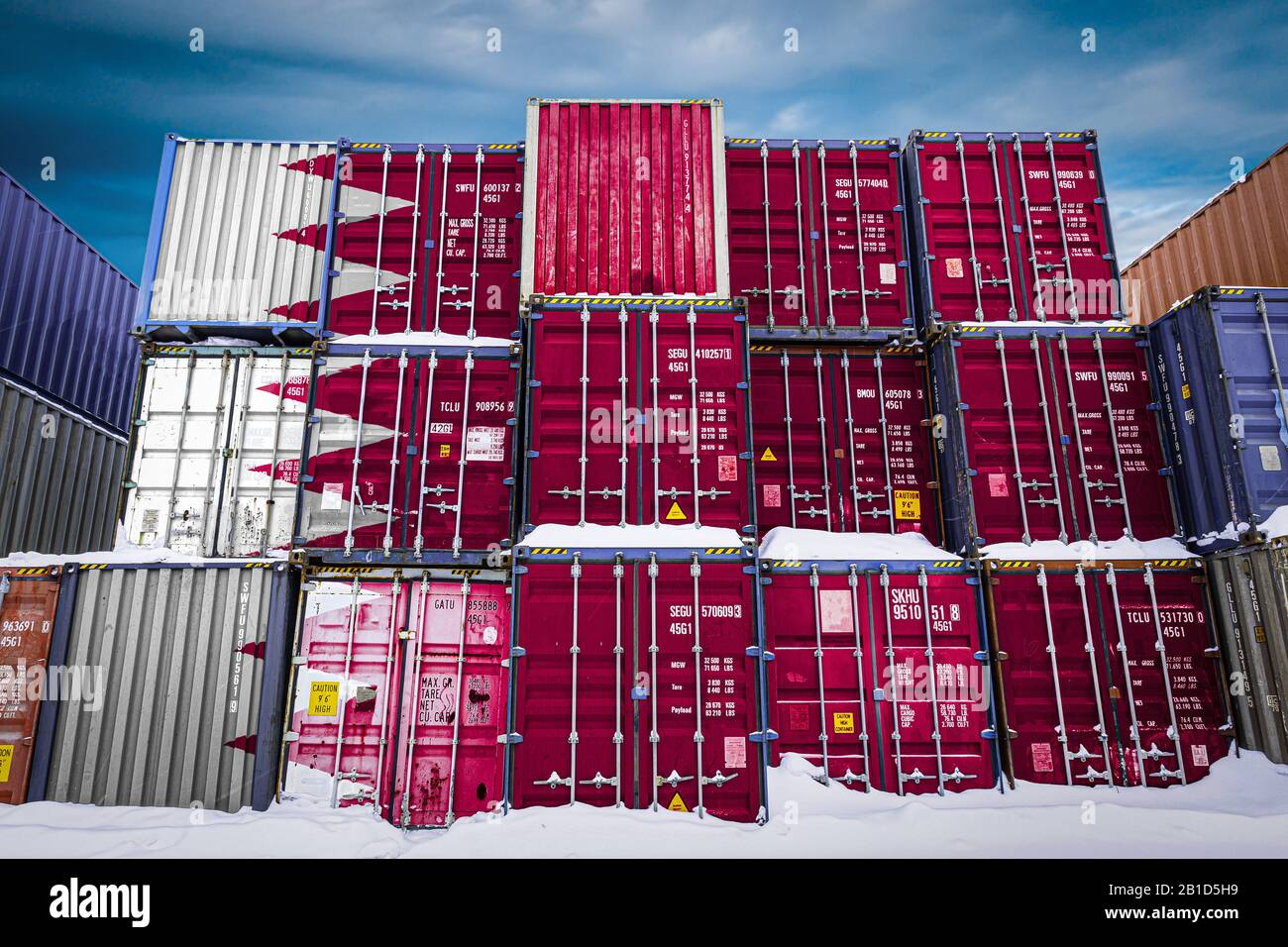 The national flag of Qatar on a large number of metal containers for ...