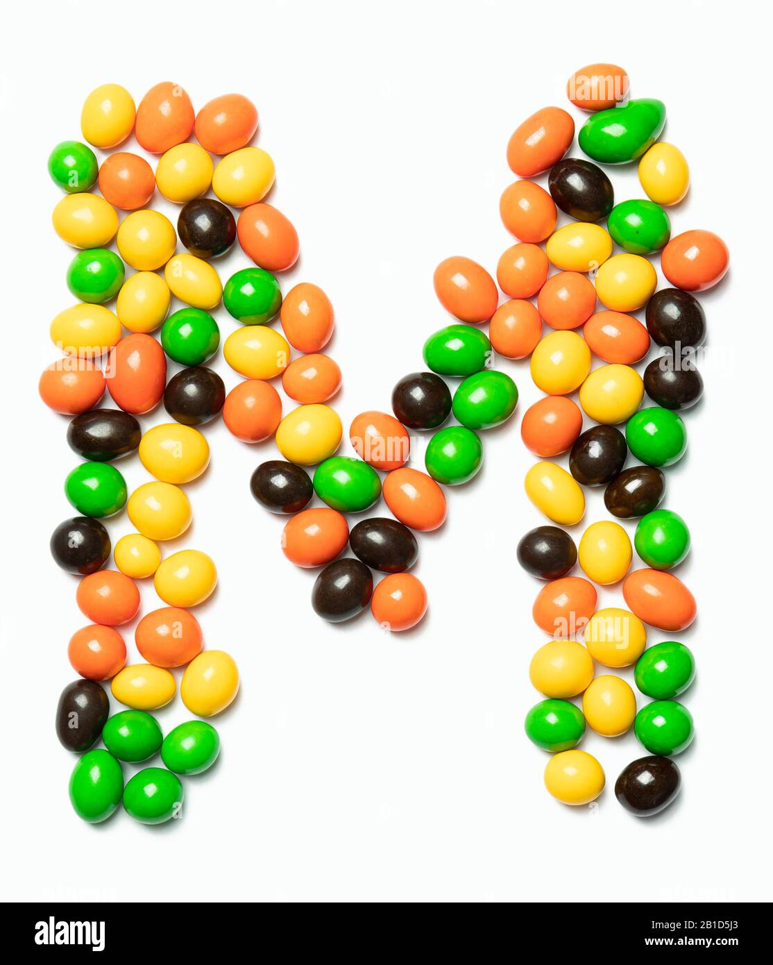 Letter M of the English alphabet from multicolored round chocolates on ...