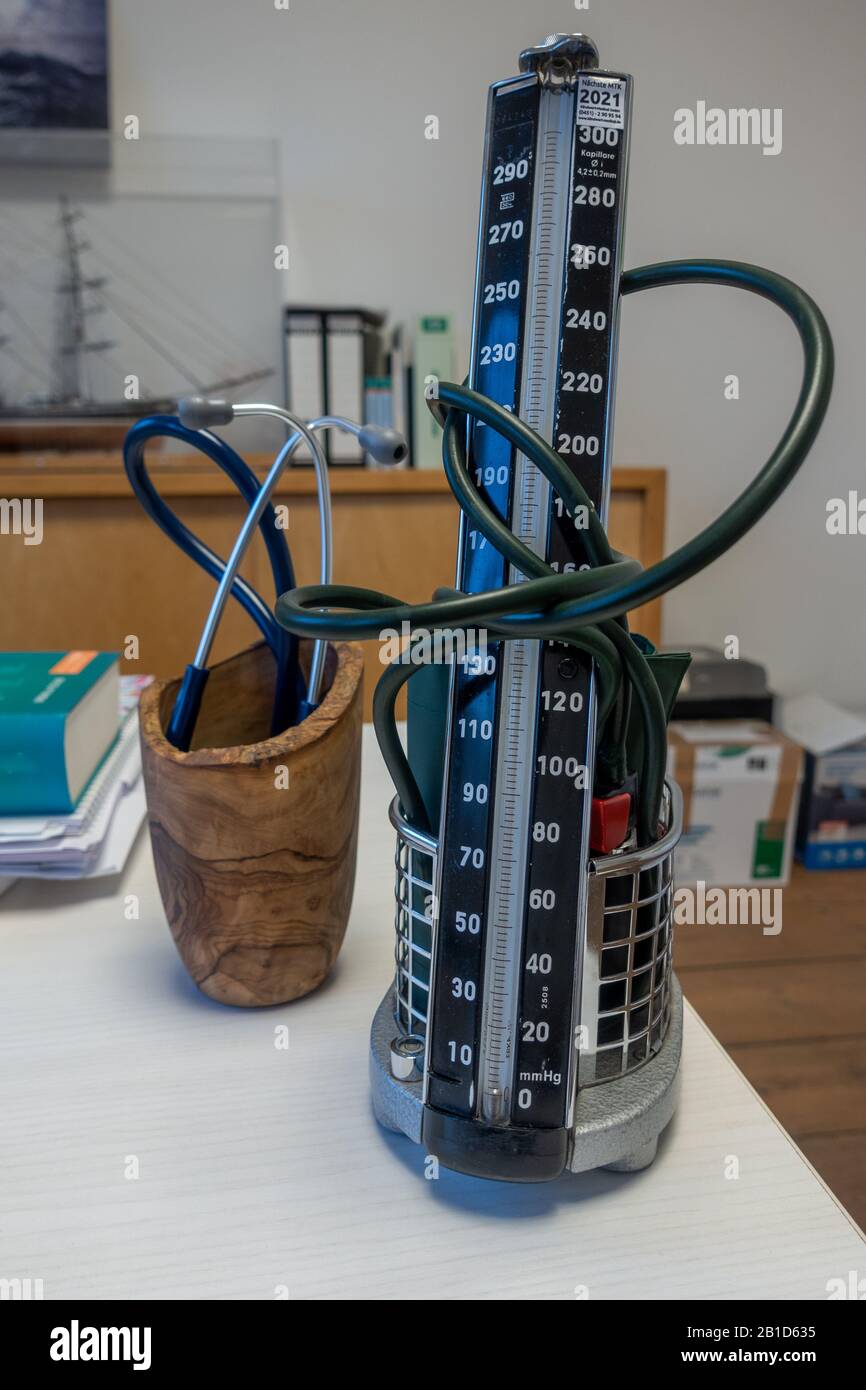 on the desk of a doctor's practice is an old blood pressure monitor and ...