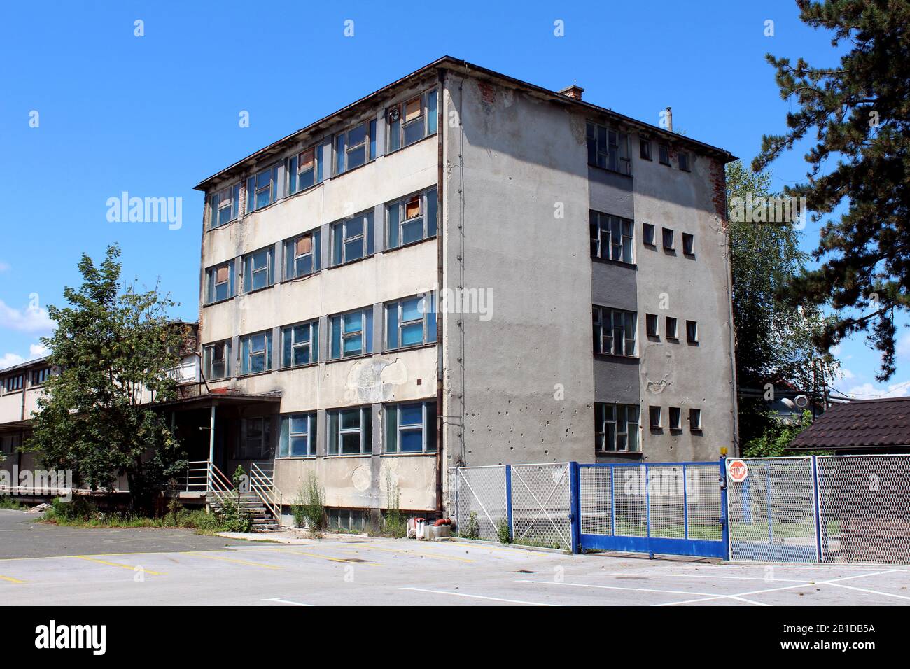 Abandoned small office building with cracked dilapidated facade and ...