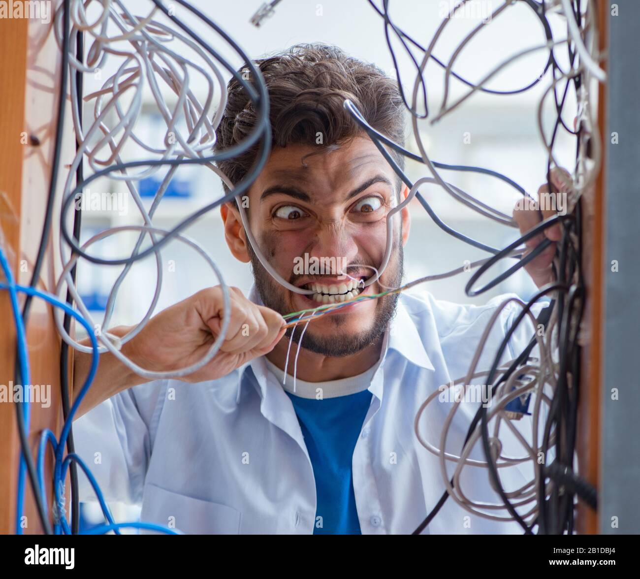 The electrician trying to untangle wires in repair concept Stock Photo ...