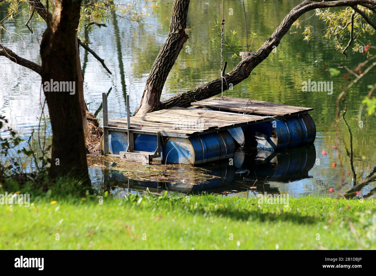 Dilapidated homemade river platform made from blue metal barrels and ...