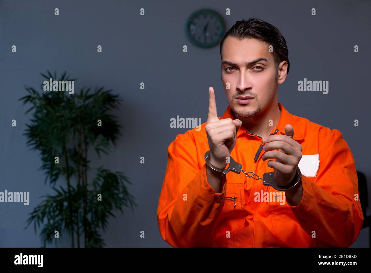 The young convict man sitting in dark room Stock Photo - Alamy