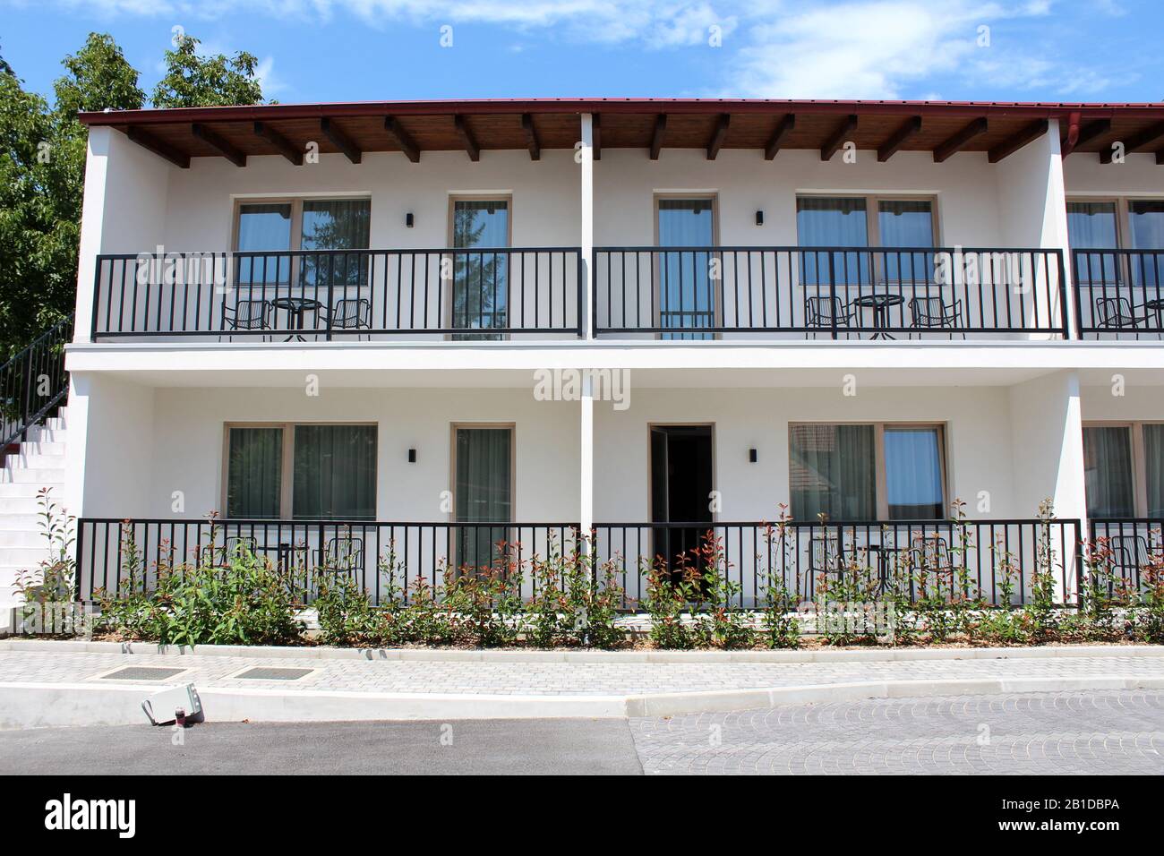 Front view of row of newly built motel room balconies with black metal ...